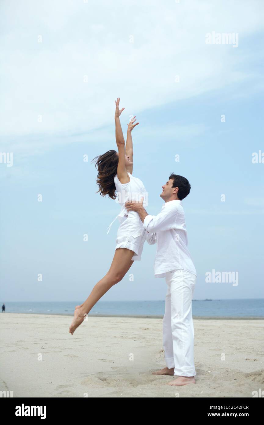 Young man lifts woman up in the air Stock Photo - Alamy