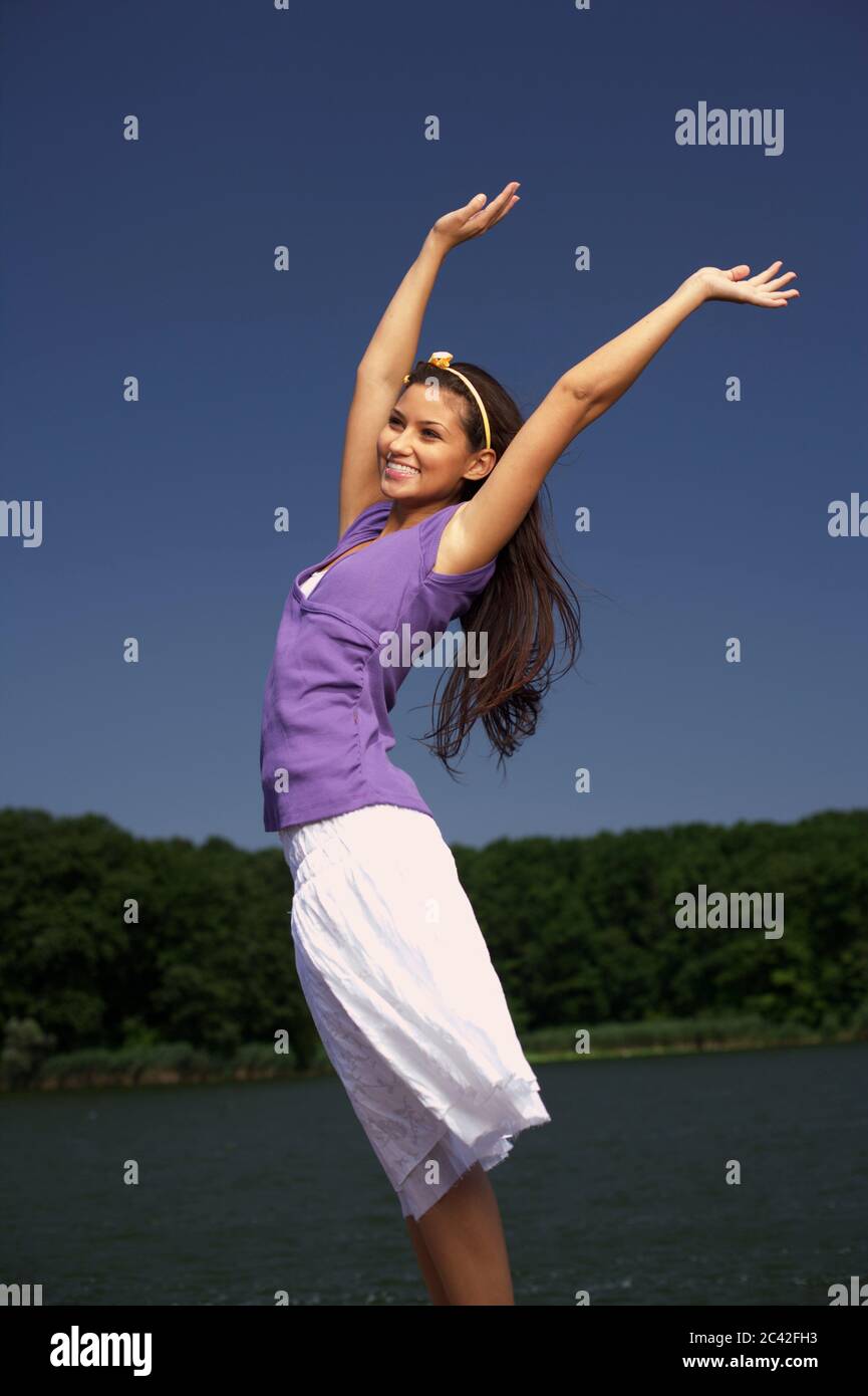 Young woman raises her arms Stock Photo - Alamy