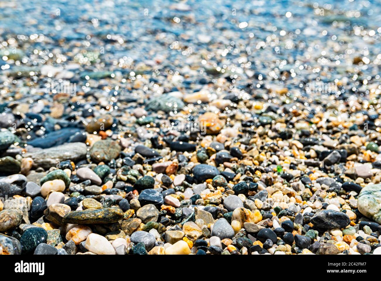 Pebbles in the water edge of a beach Stock Photo - Alamy