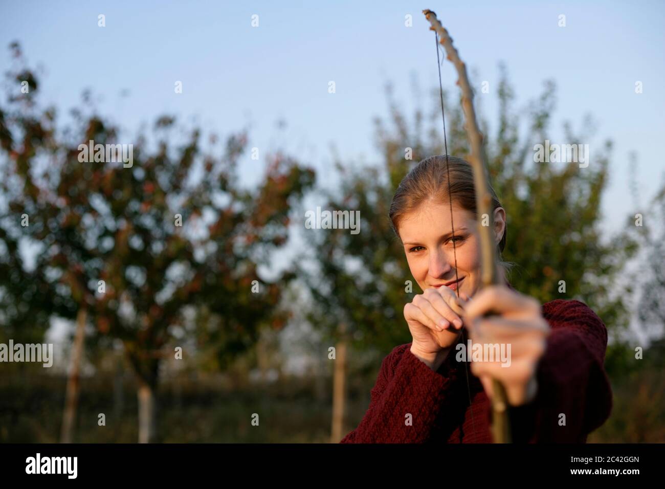 Woman is aiming the camera with a bow and arrow Stock Photo - Alamy