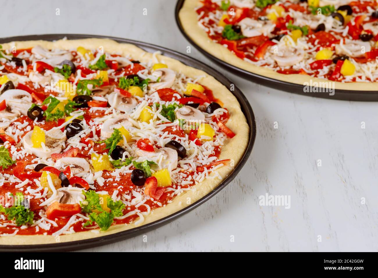 Round uncooked pizza with pepperoni and mushroom on white table Stock ...