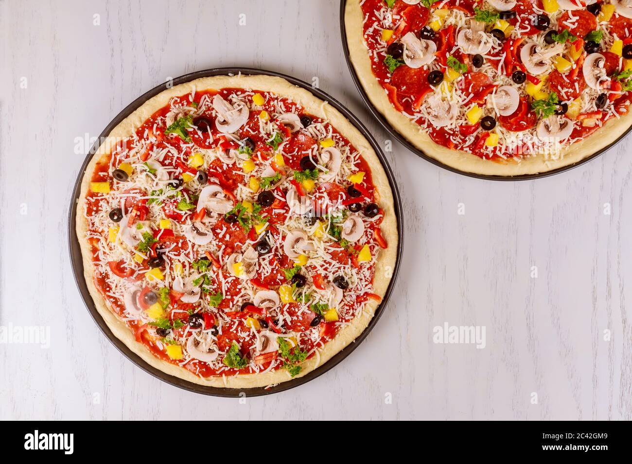 Two round raw supreme pizza with pepperoni on white background Stock ...