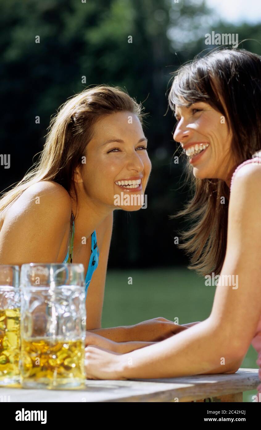 Two friends are laughing at a beer bench - joy - facial expressions ...