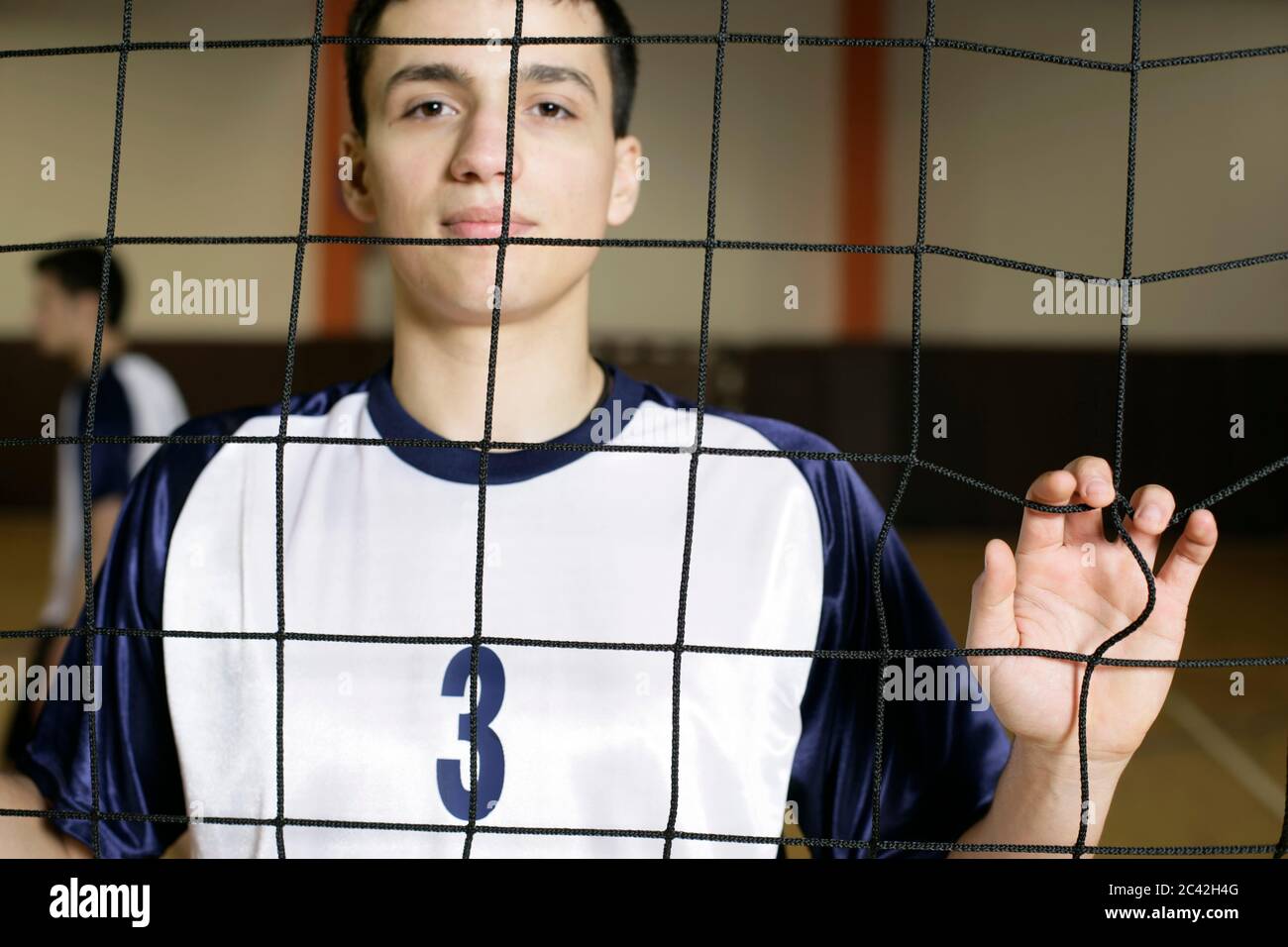 Volleyball player is on the net and looks at the camera Stock Photo - Alamy