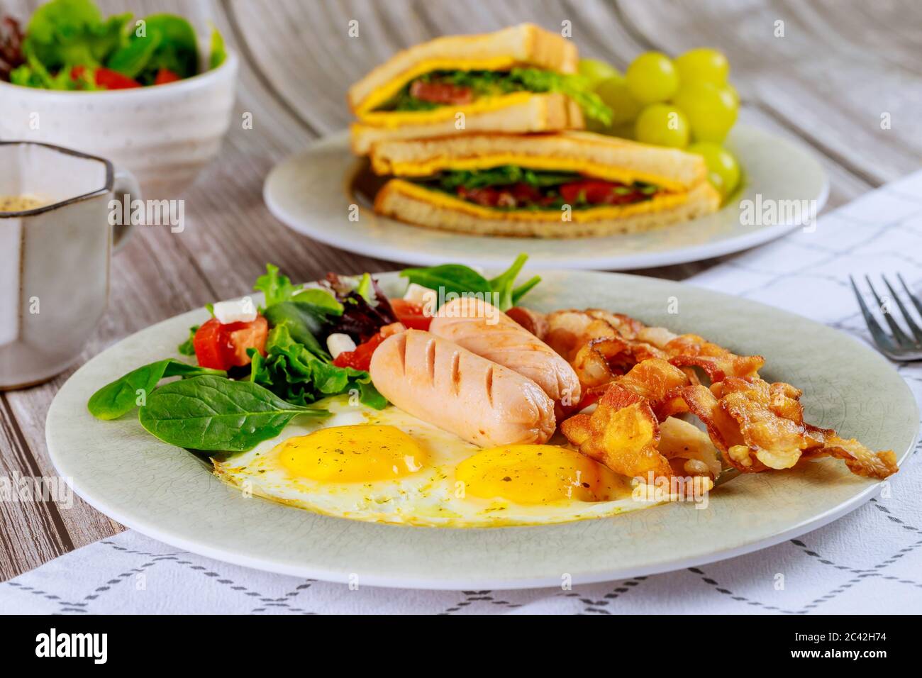 Delicious breakfast with eggs, sausages, bacon, toast and cup of coffee ...