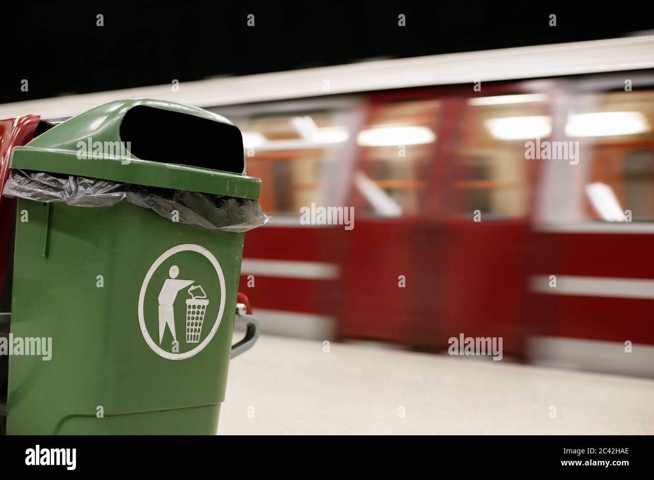 Green waste paper basket behind which a subway passes - train station ...