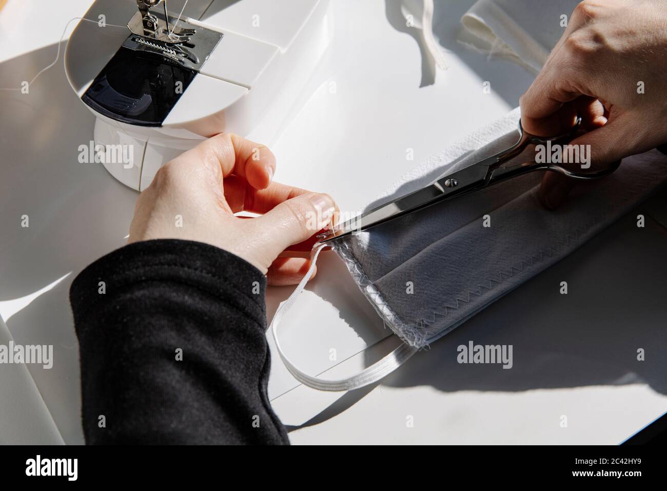 High angle of crop female cutting thread in a fabric protective face ...