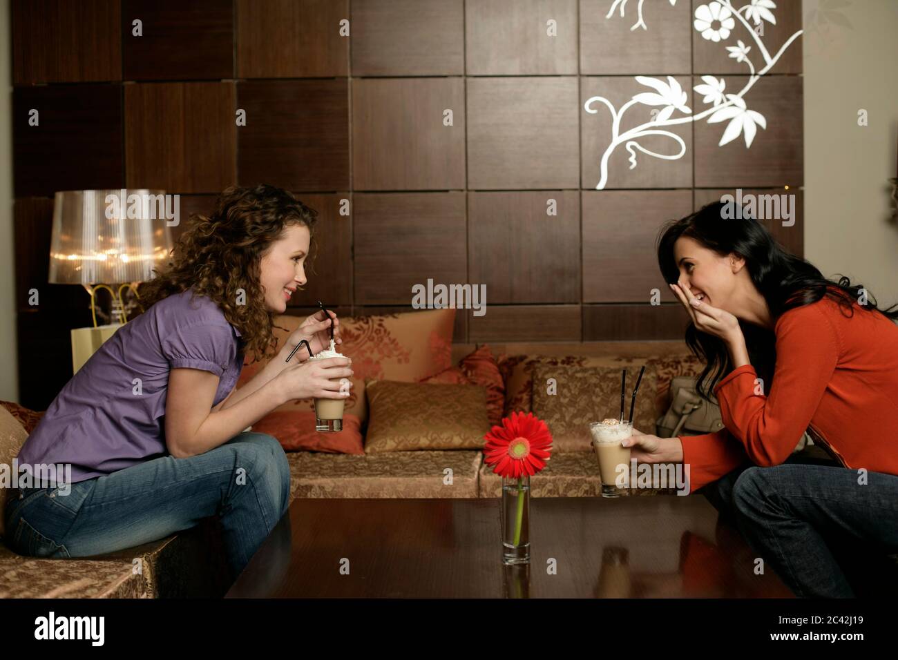 Two young women sit opposite each other Stock Photo - Alamy