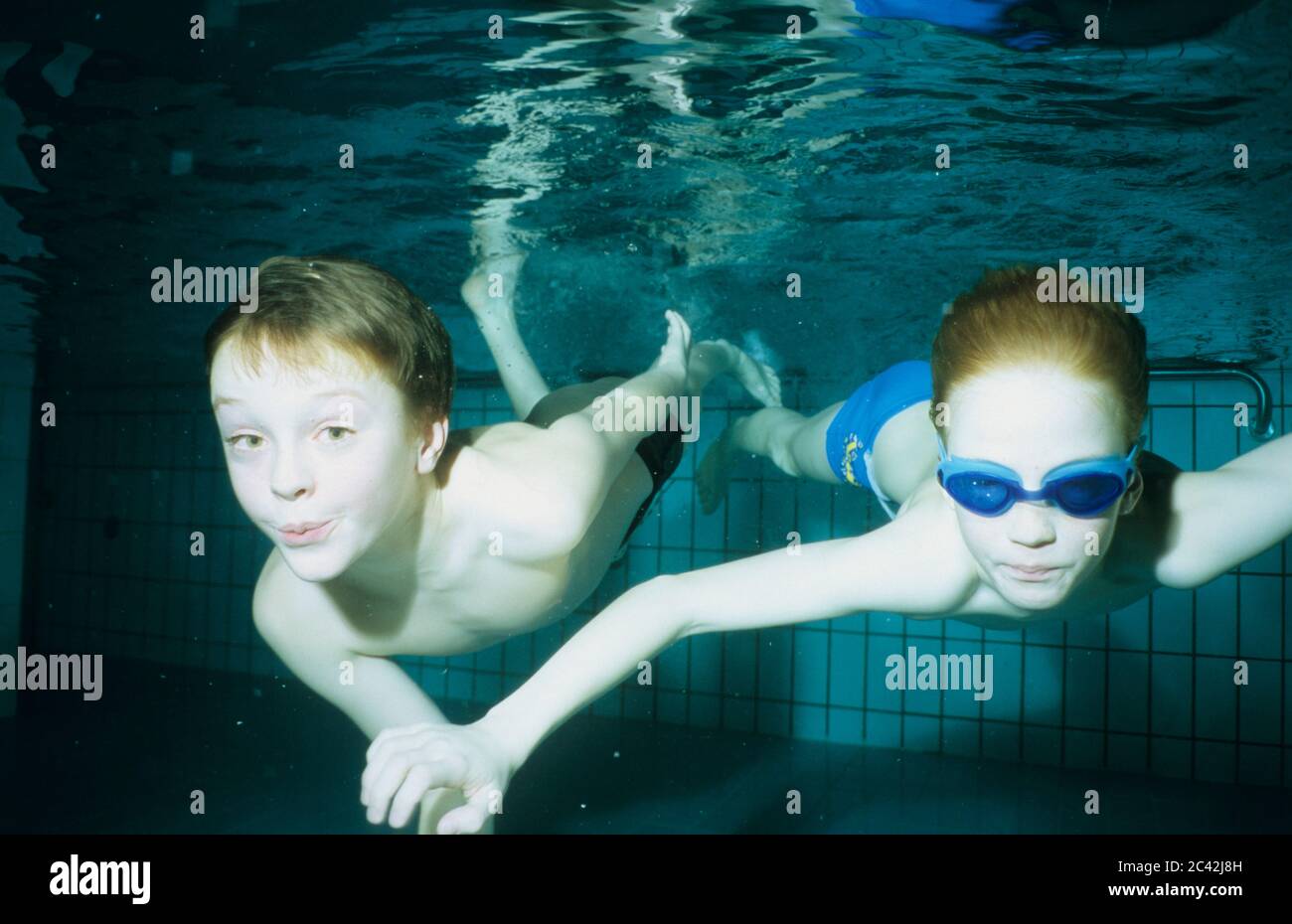 Two boys dive hand in hand - swimming pool - friendship - youth ...