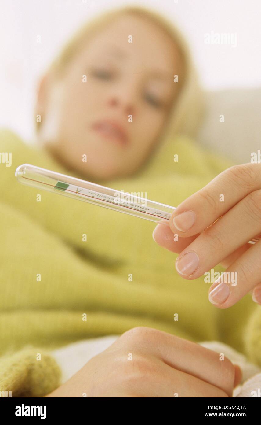 Young woman measures fever - health Stock Photo - Alamy
