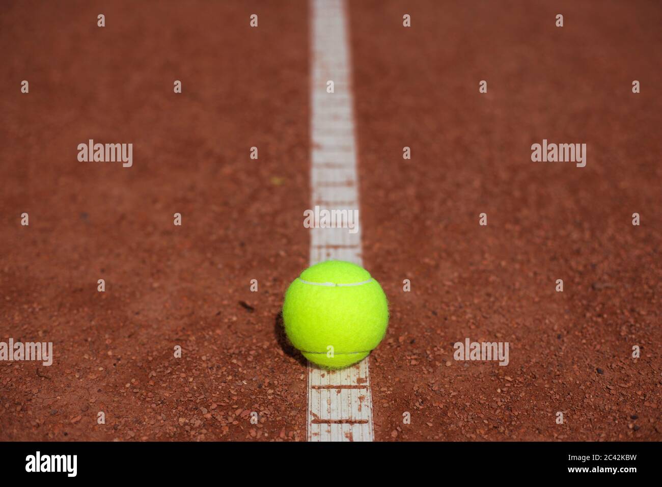 Yellow tennis ball on the line Stock Photo - Alamy
