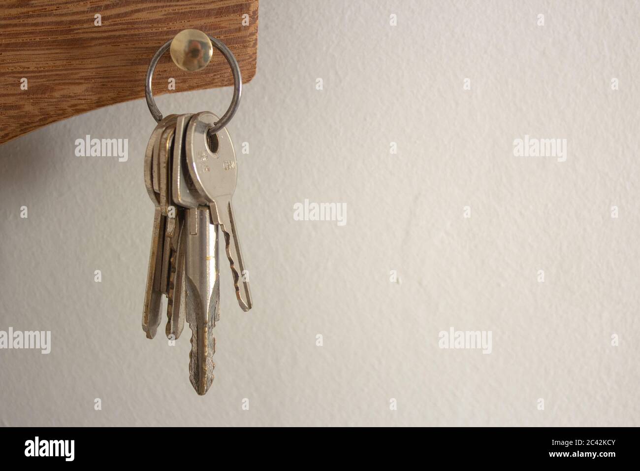 Bunch of keys hanging on a holder on a white wall Stock Photo - Alamy