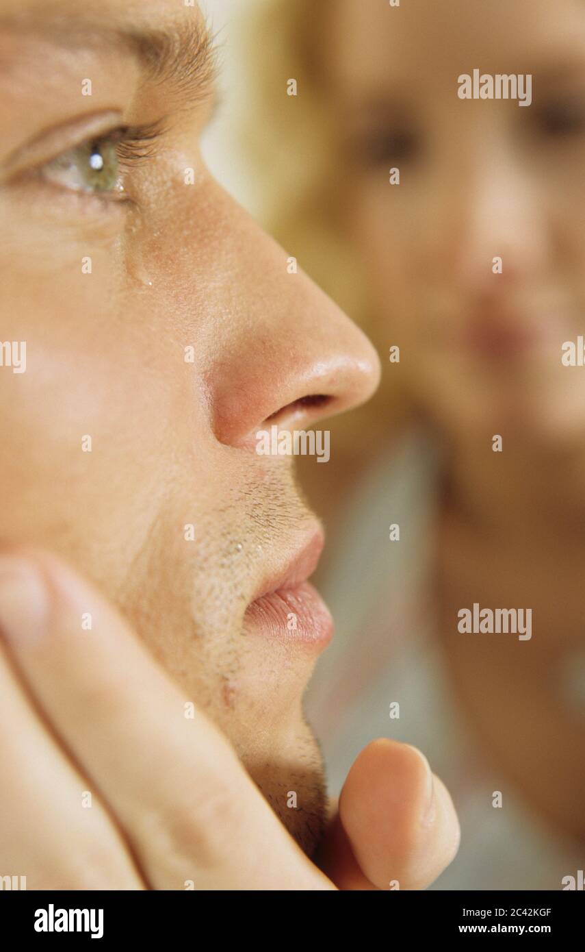 Young woman strokes crying friend's cheek - cutout - togetherness Stock ...