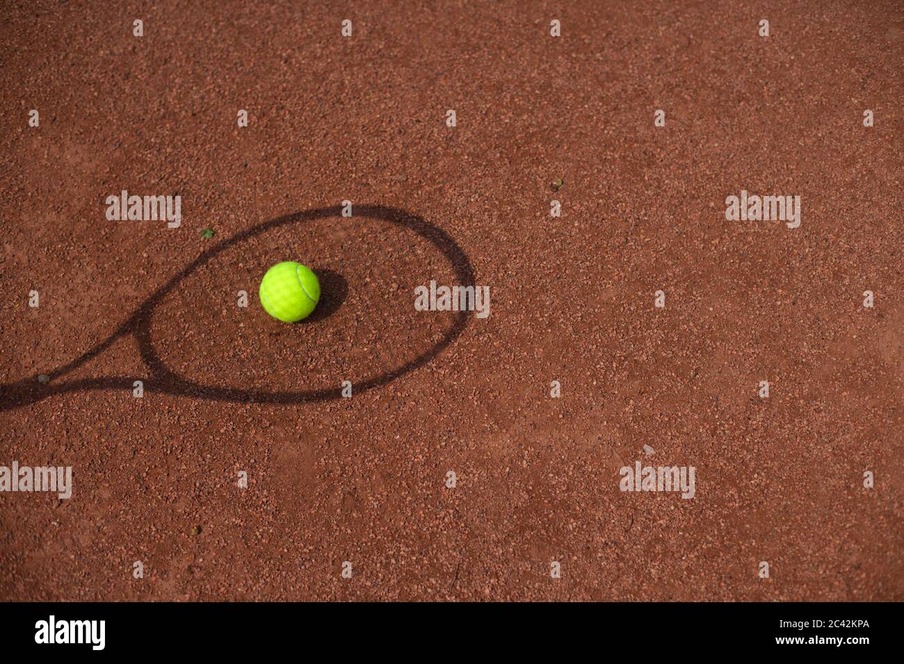 Shadow of a tennis racket on ash court and a yellow ball Stock Photo ...