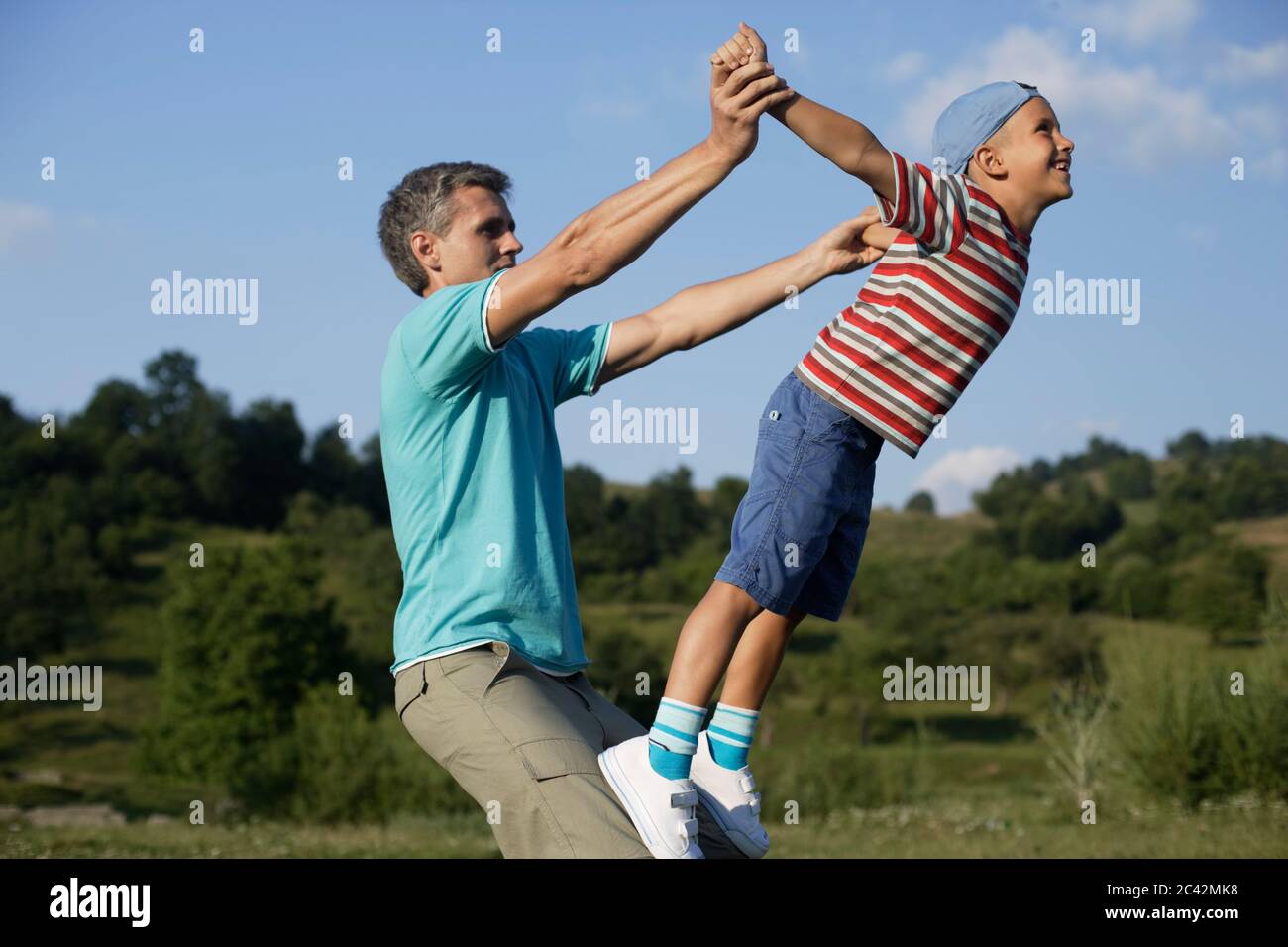 Gray-haired man lifts up a boy - aviator - fun Stock Photo - Alamy