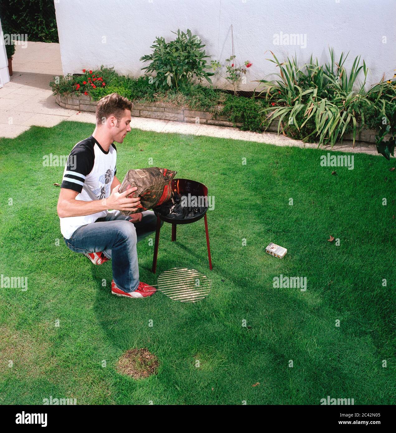 Man lights fire in grill hi-res stock photography and images - Alamy
