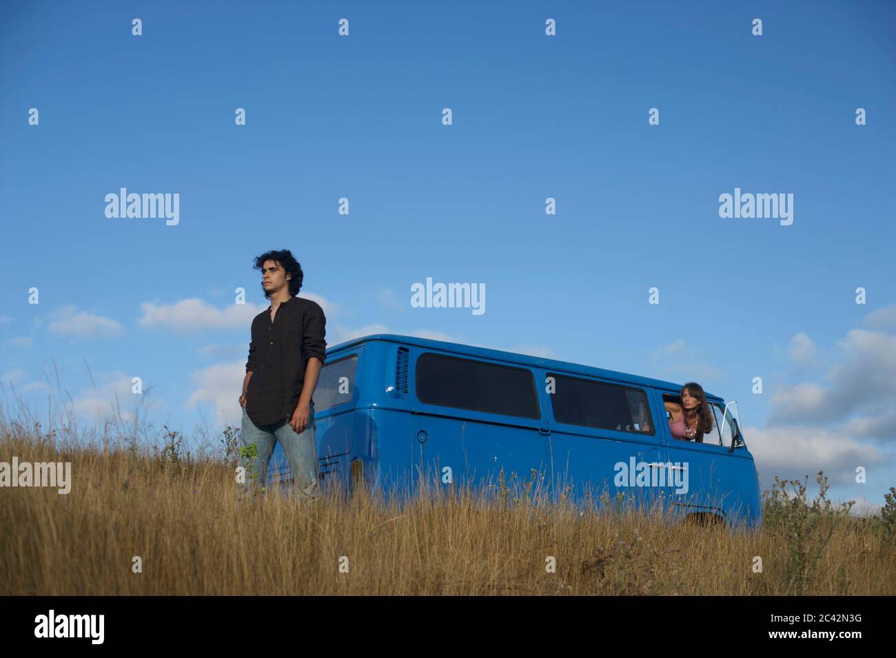 Young man is standing behind a bus Stock Photo - Alamy