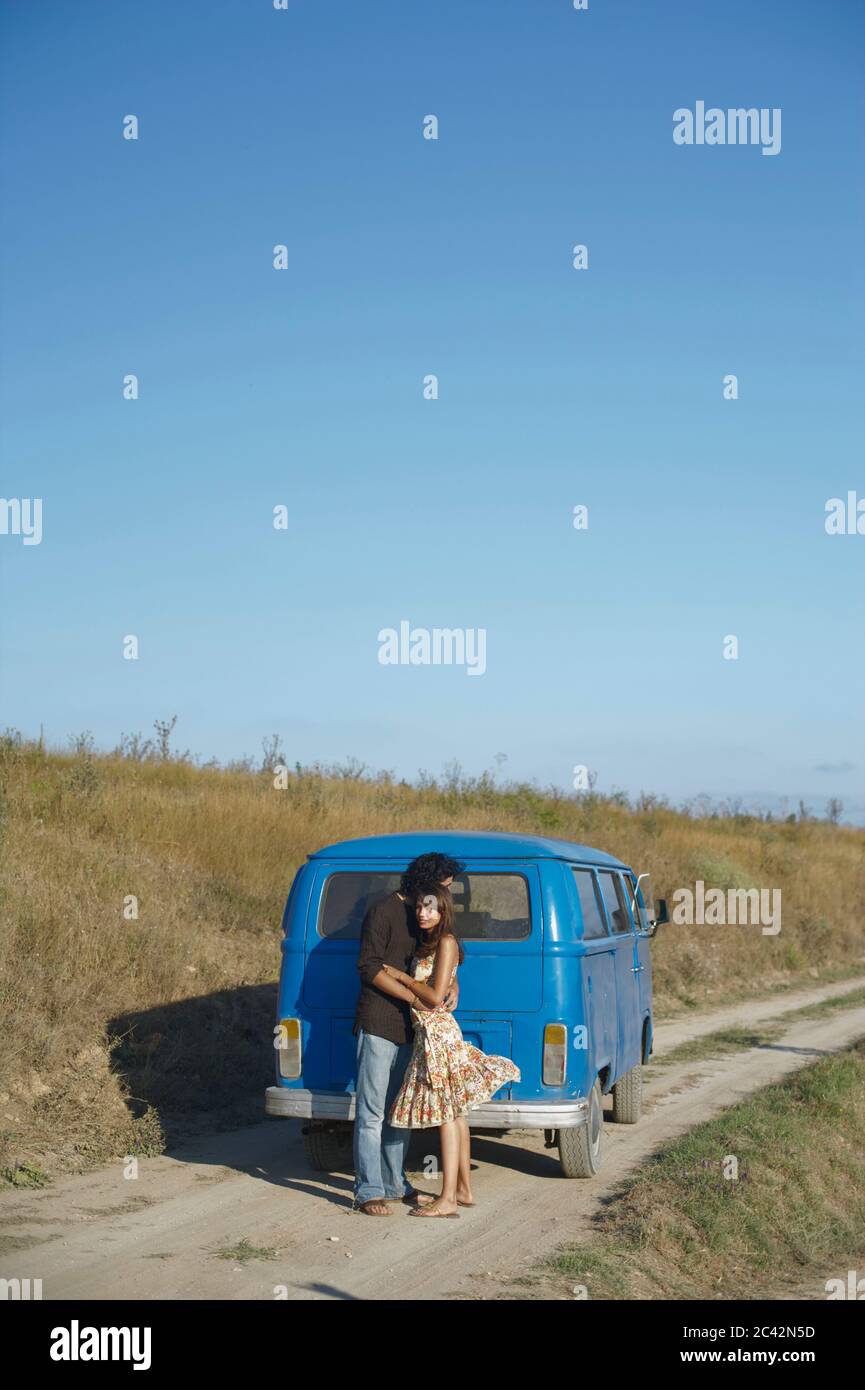 Young couple hugging behind a bus Stock Photo - Alamy