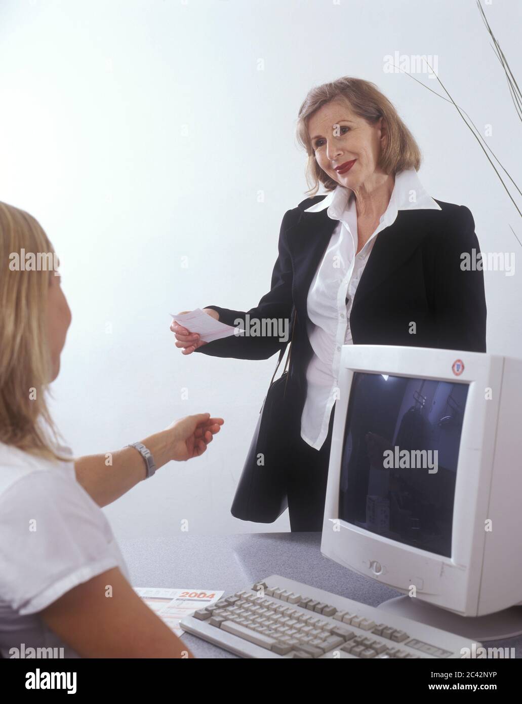 Secretary gives patient an appointment slip - doctor's office Stock ...