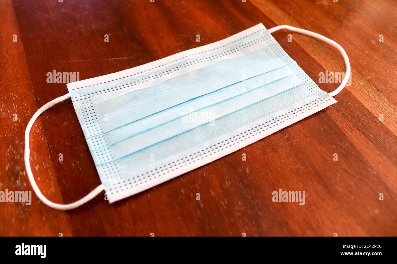 Light blue medical mask with rubber ear straps to cover the mouth and ...