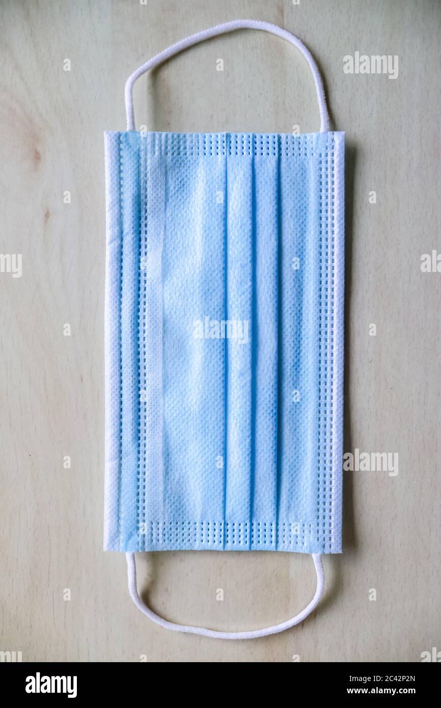 Light blue medical mask with rubber ear straps to cover the mouth and ...