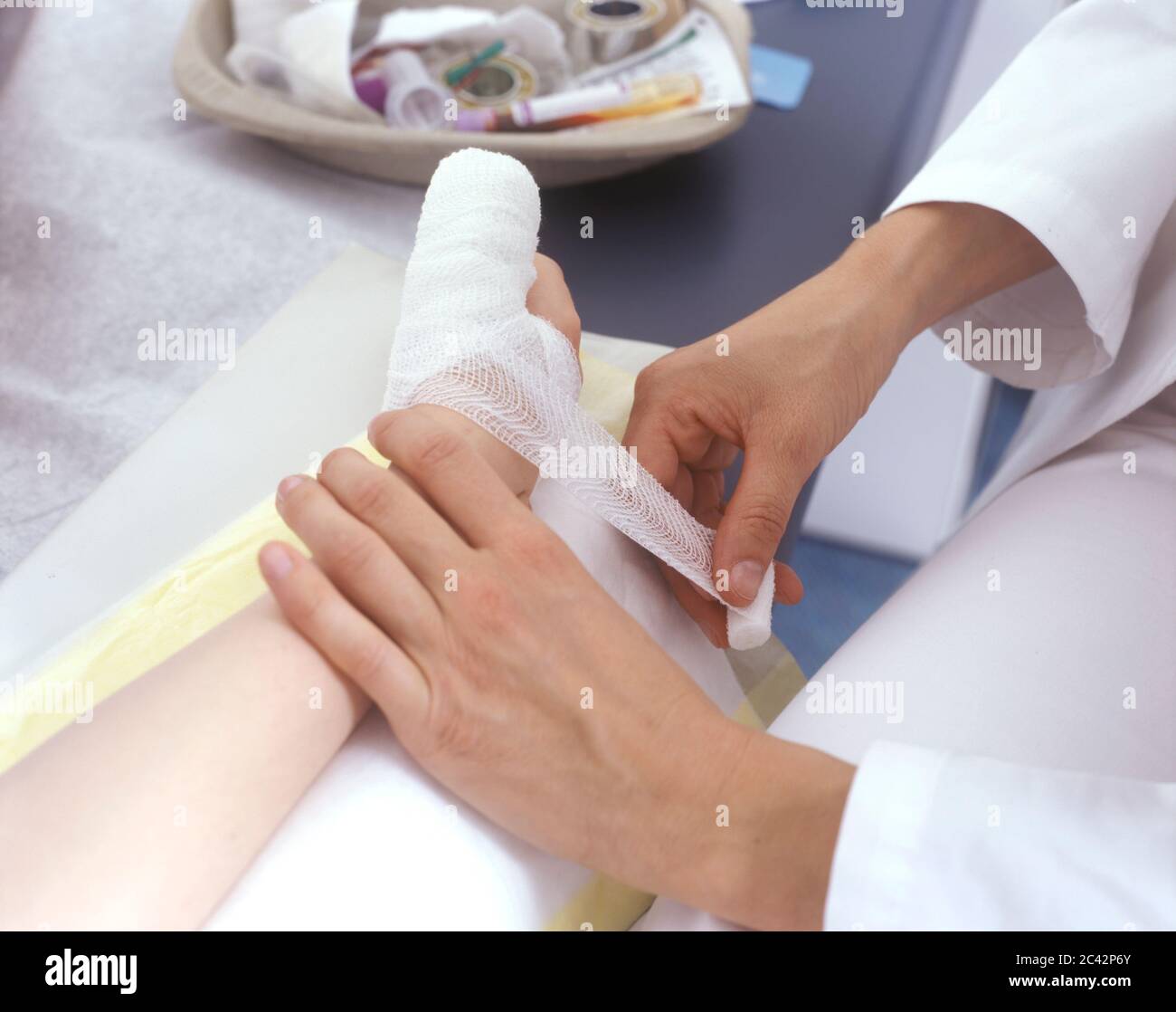 Female doctor bandages a little boy's thumb - treatment - doctor's ...