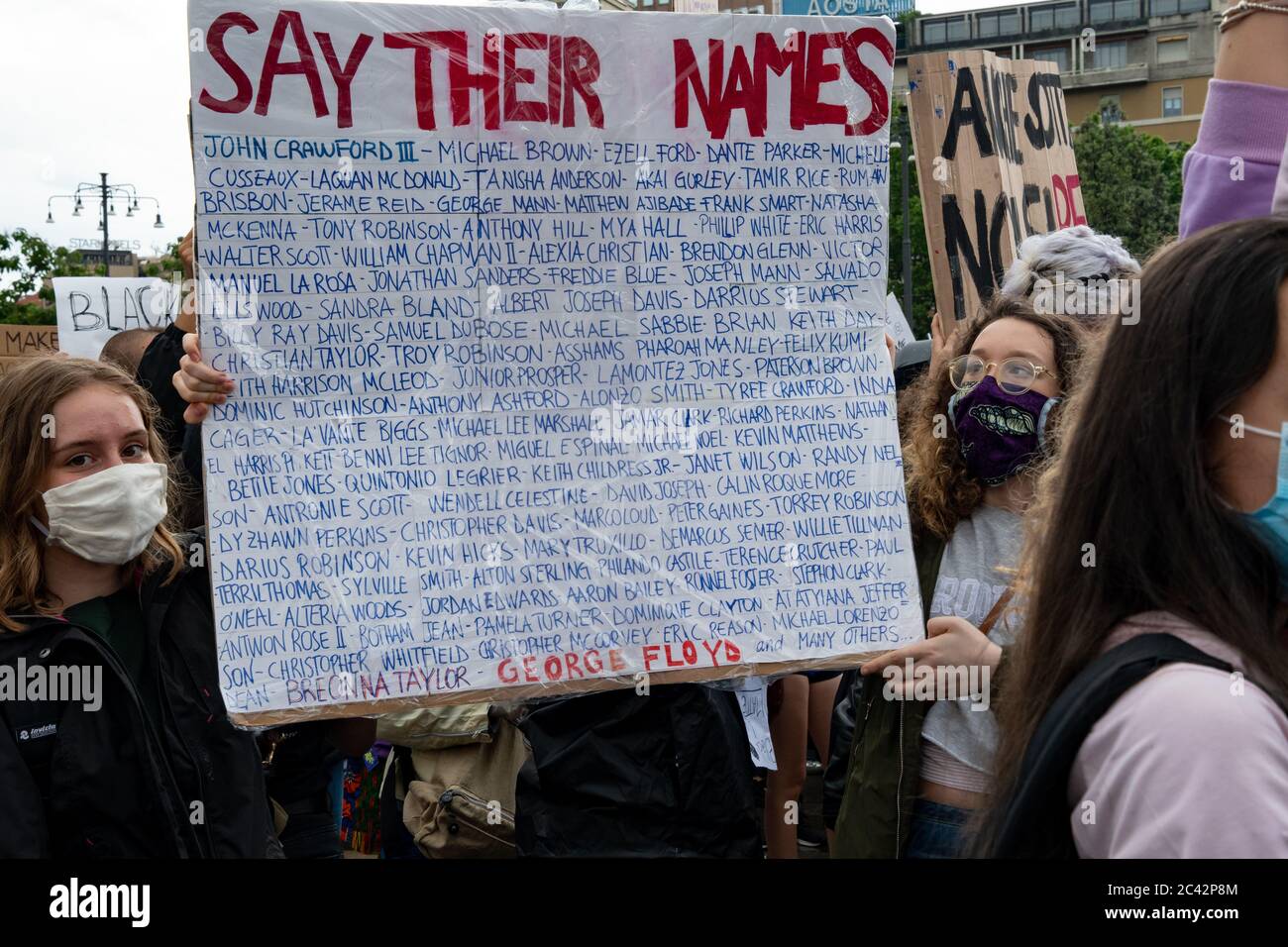 In front of Milan central station young protesters holding board "Say ...
