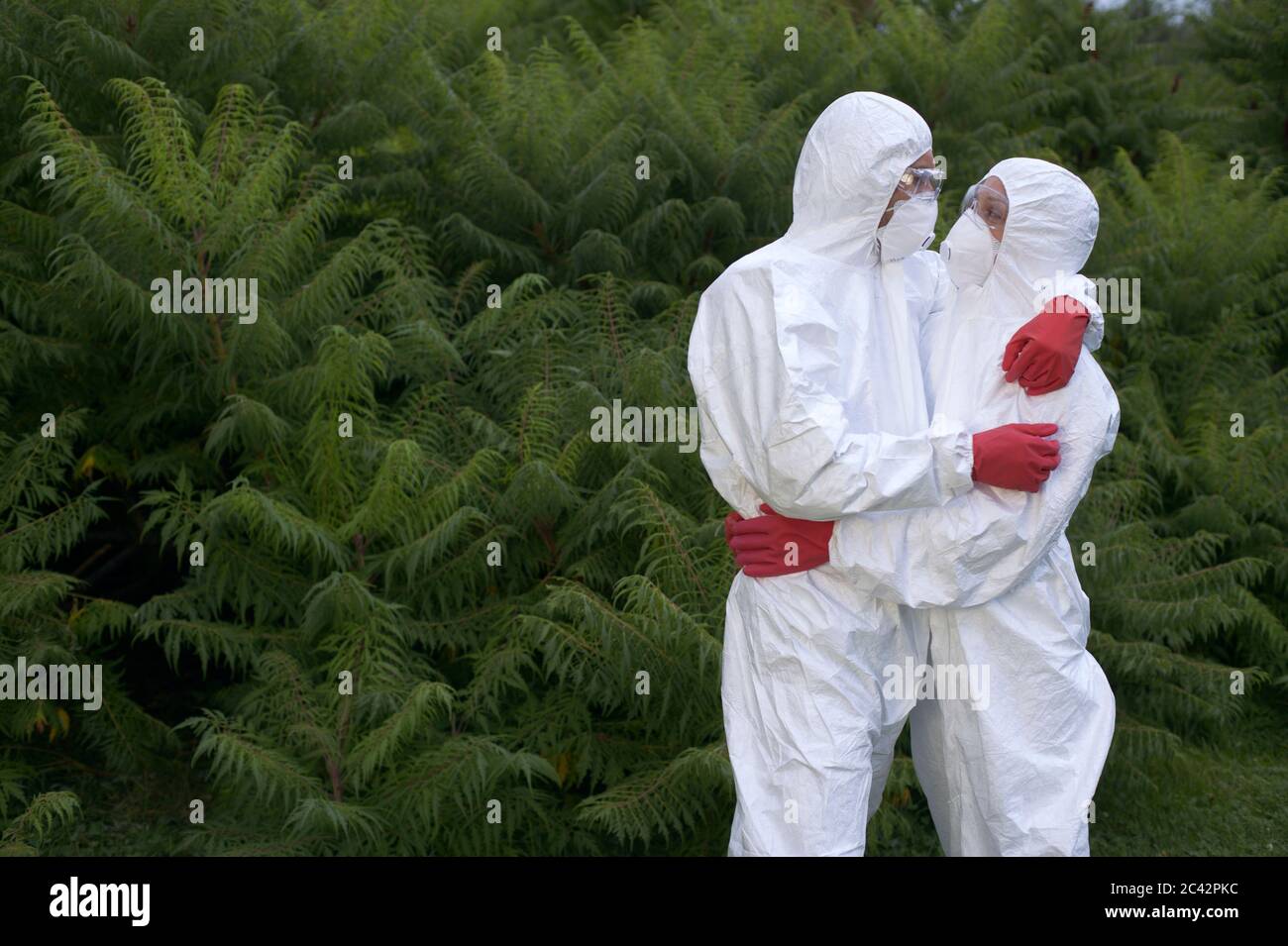 Two people in protective suits hug each other Stock Photo - Alamy