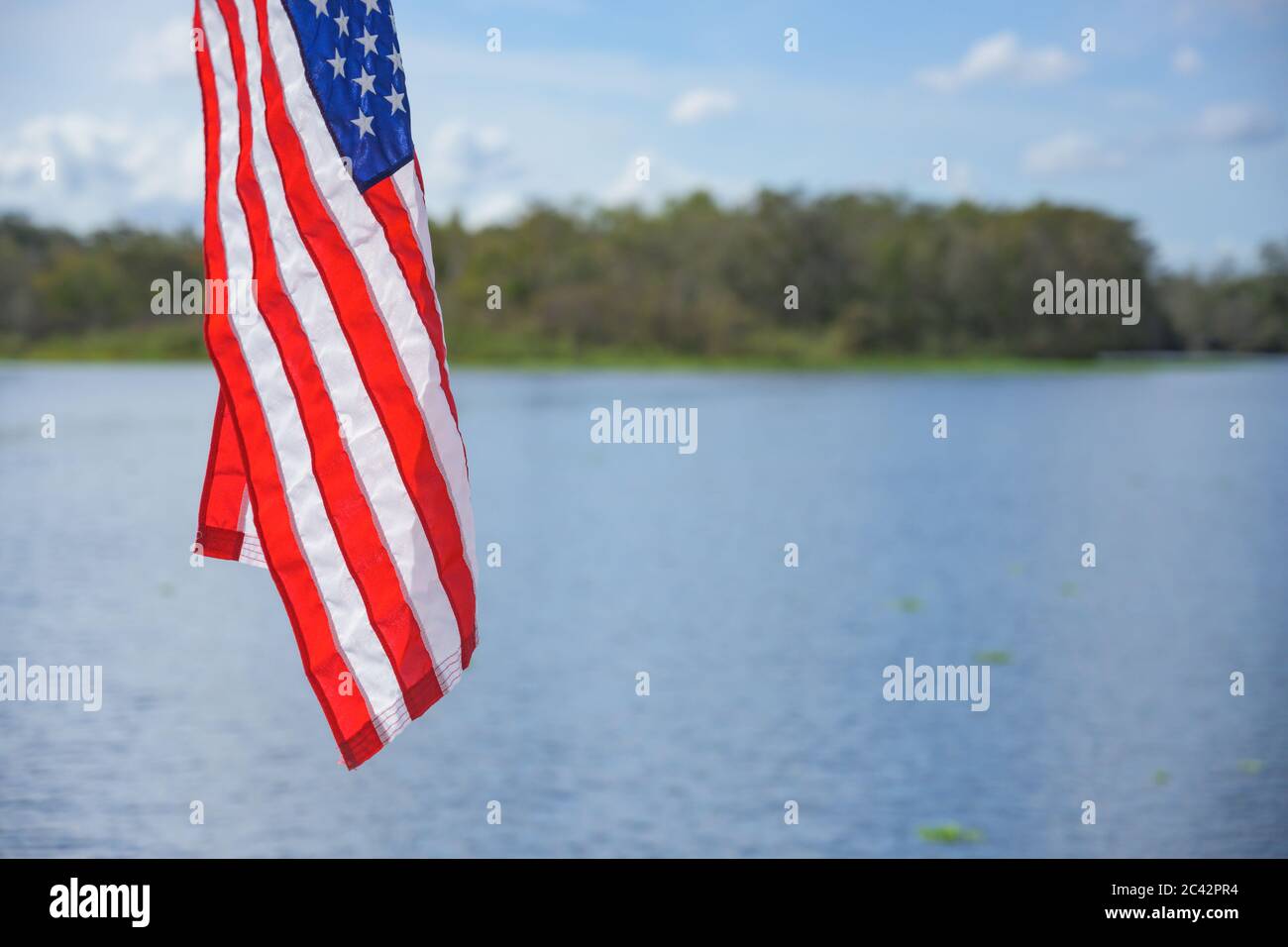 American Flag Hangs Over Water with copy space Stock Photo - Alamy