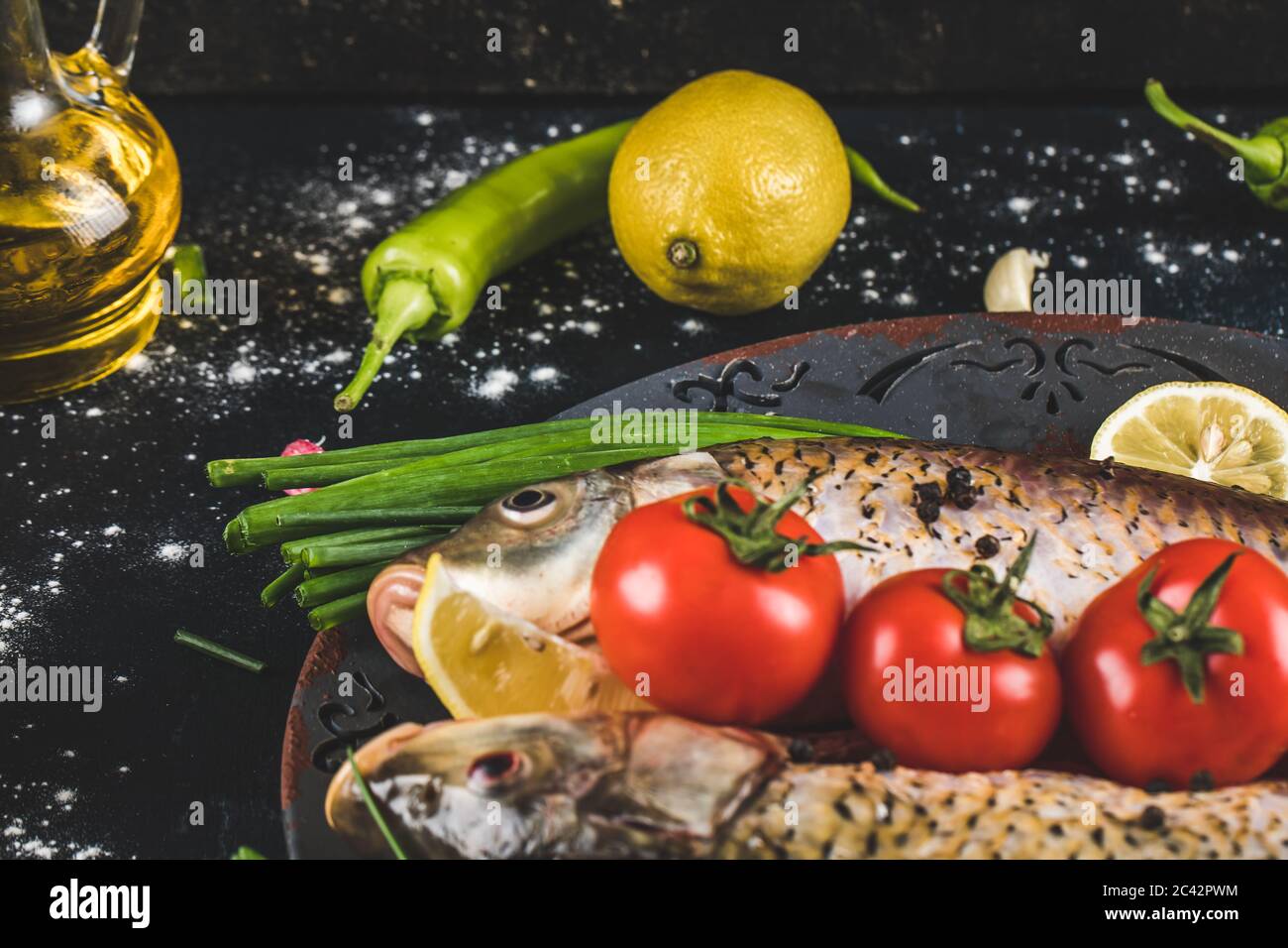 Raw fish meat with green chilies, lemon and tomatoes Stock Photo - Alamy