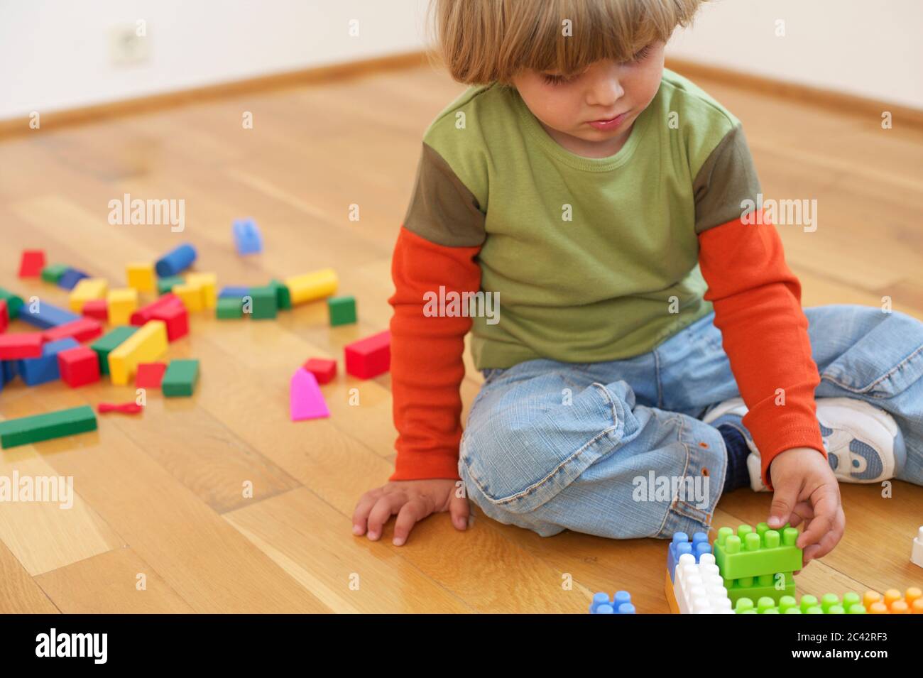Little boy is playing with blocks on the floor - childhood Stock Photo ...