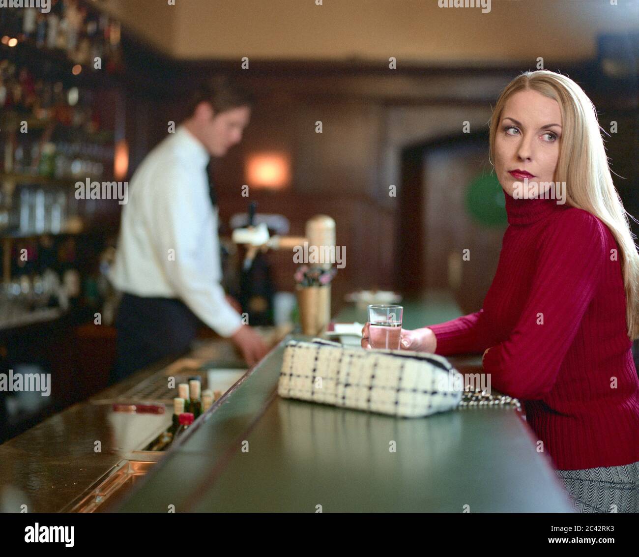 Blond woman waiting at bar counter Stock Photo - Alamy