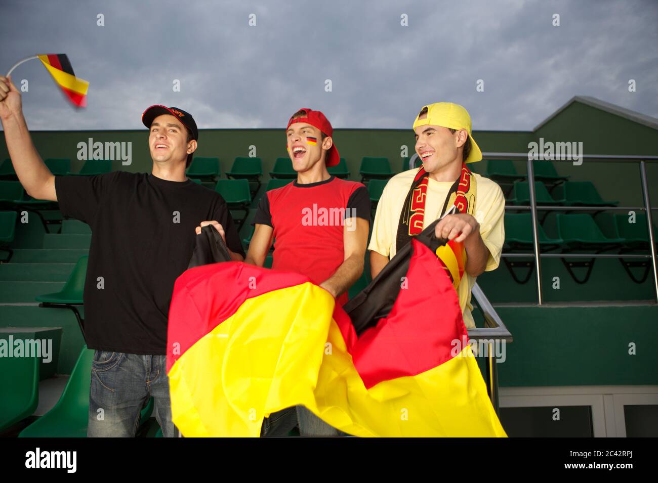 Three young German fans sit in the stadium Stock Photo - Alamy