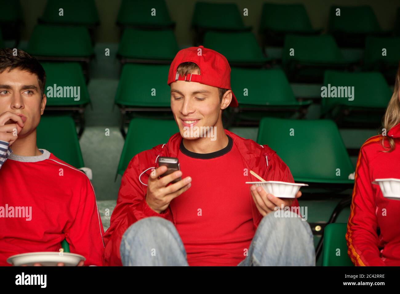 Three young fans are sitting in the stadium Stock Photo - Alamy