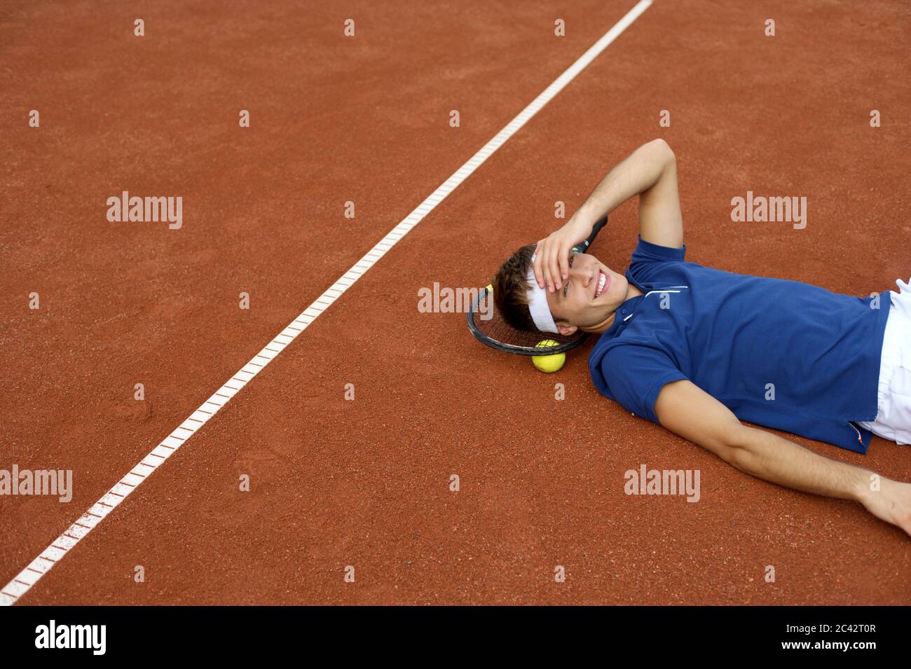 Exhausted young man lies on a tennis court - break - match Stock Photo ...