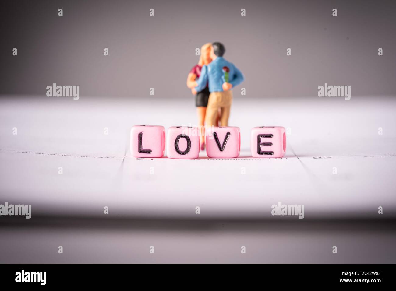 Love concept. Miniature couple against pink background Stock Photo - Alamy