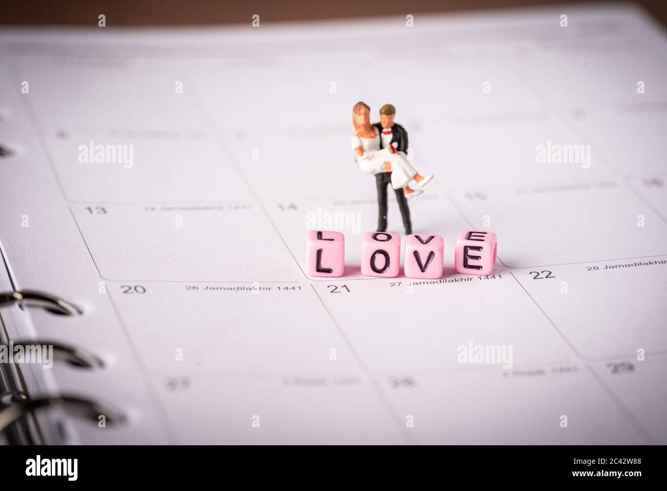 Love concept. Miniature couple against pink background Stock Photo - Alamy