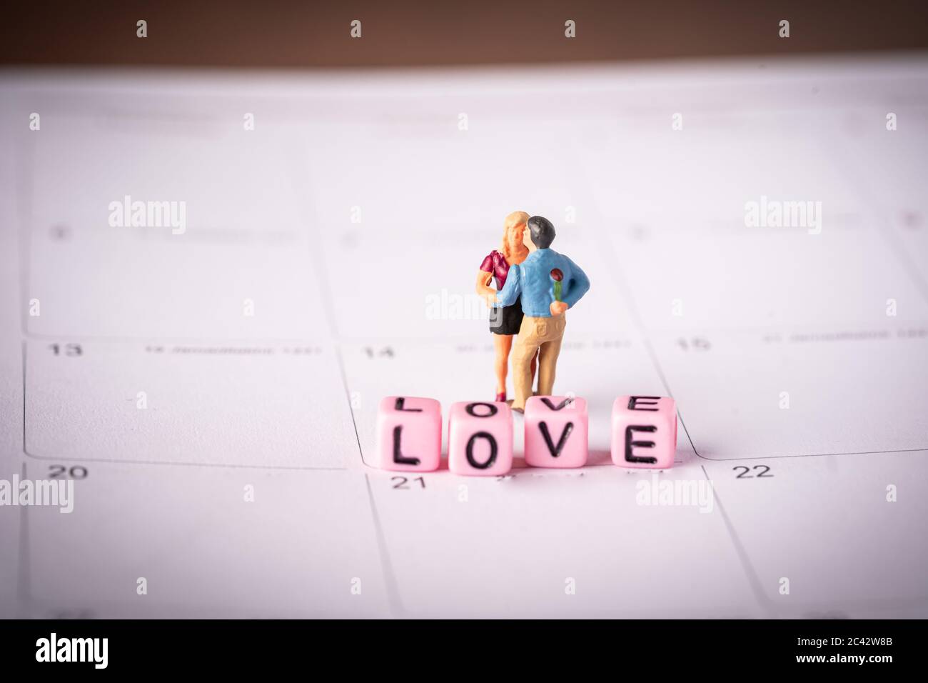Love concept. Miniature couple against pink background Stock Photo - Alamy