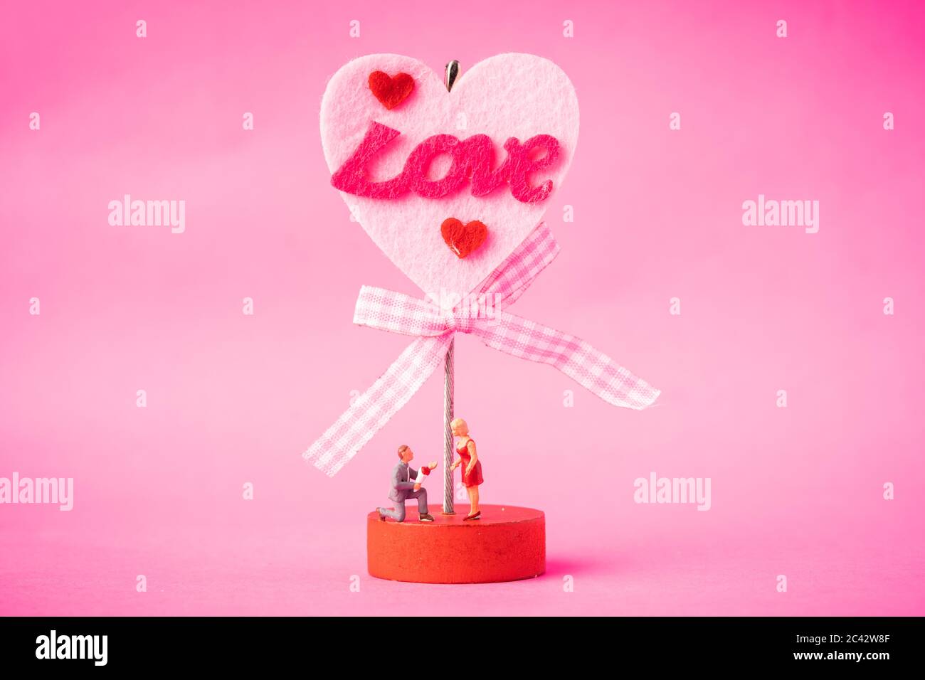 Love concept. Miniature couple against pink background Stock Photo - Alamy