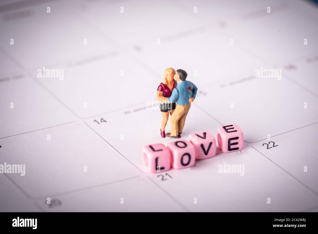 Love concept. Miniature couple against pink background Stock Photo - Alamy