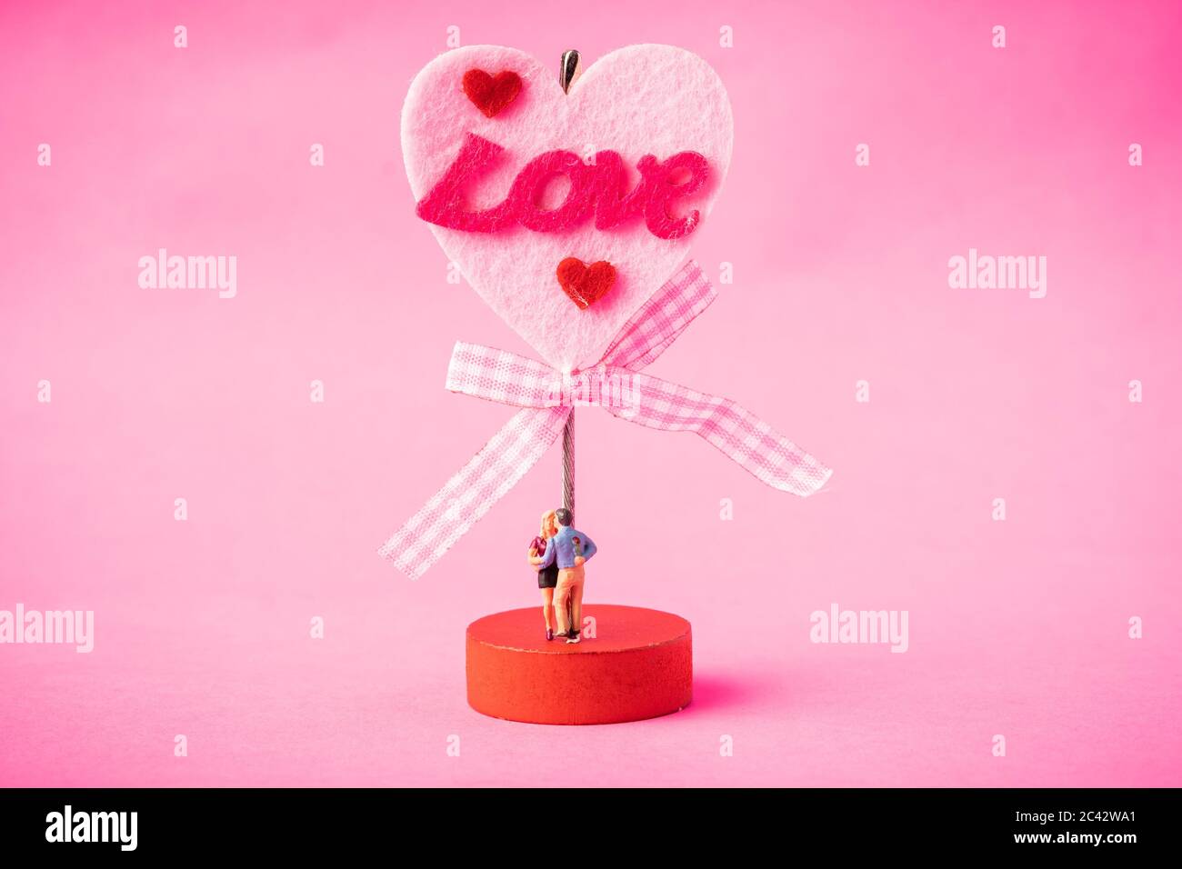 Love concept. Miniature couple against pink background Stock Photo - Alamy