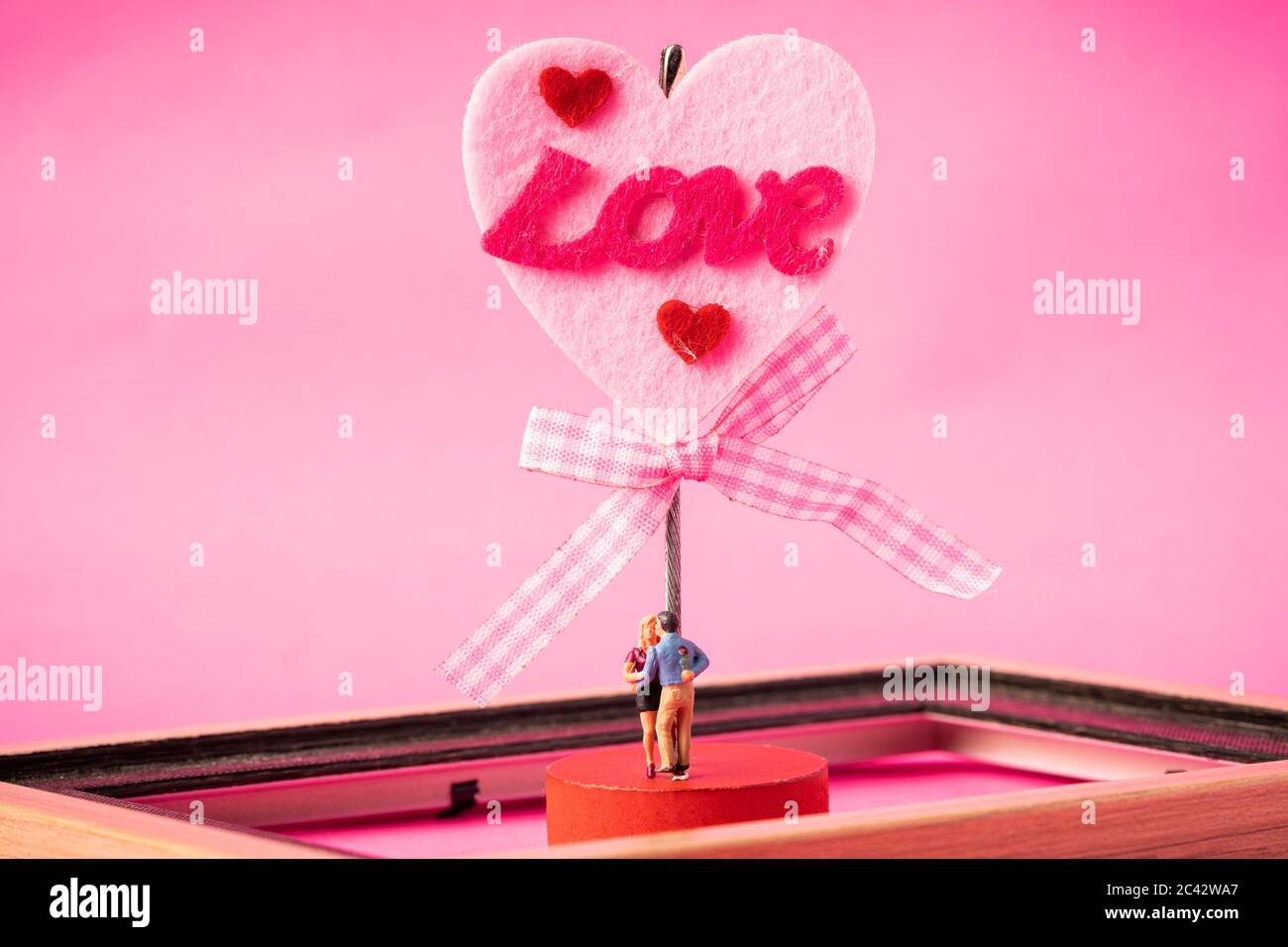 Love concept. Miniature couple against pink background Stock Photo - Alamy