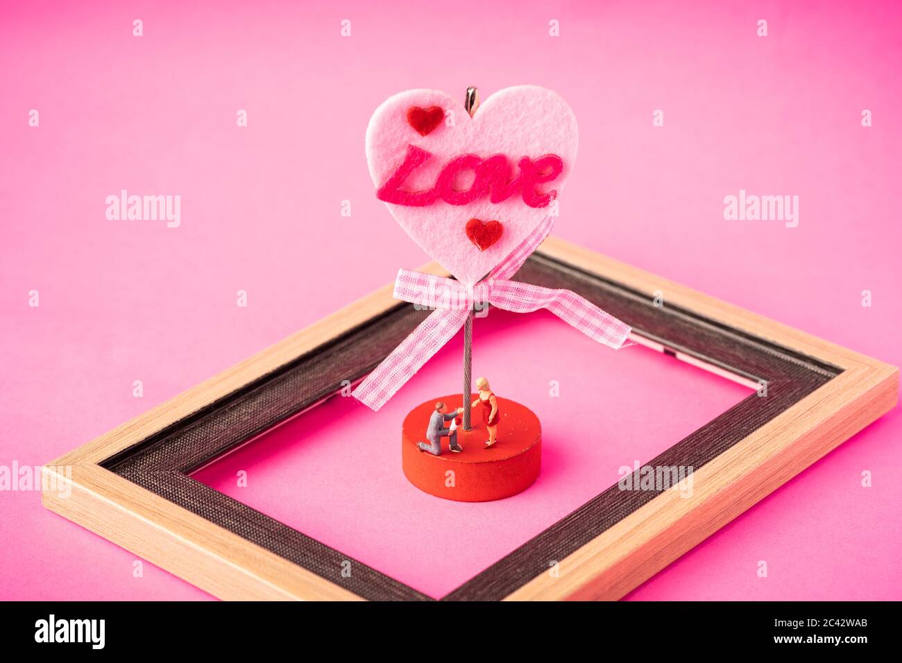 Love concept. Miniature couple against pink background Stock Photo - Alamy
