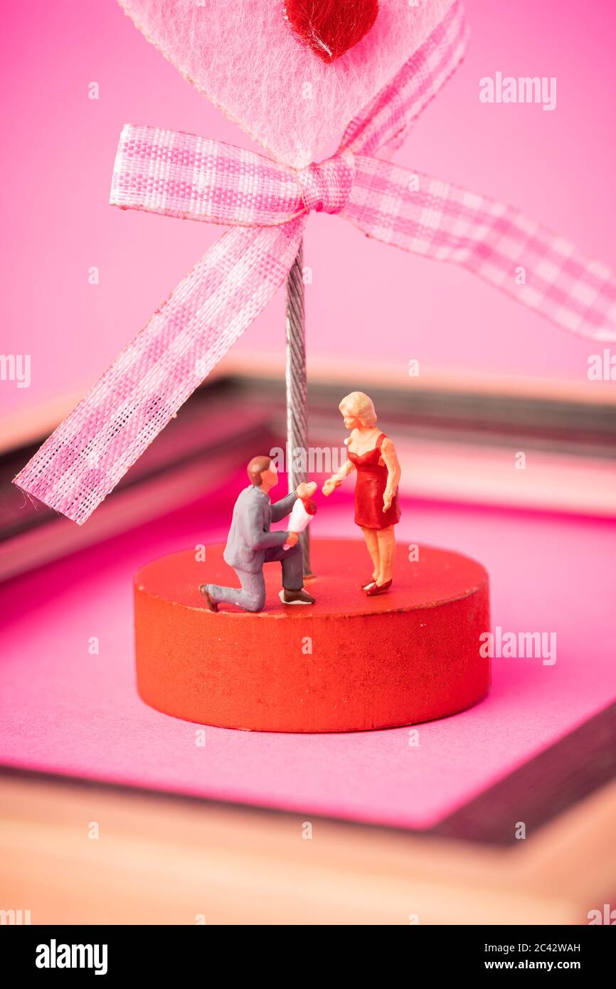 Love concept. Miniature couple against pink background Stock Photo - Alamy
