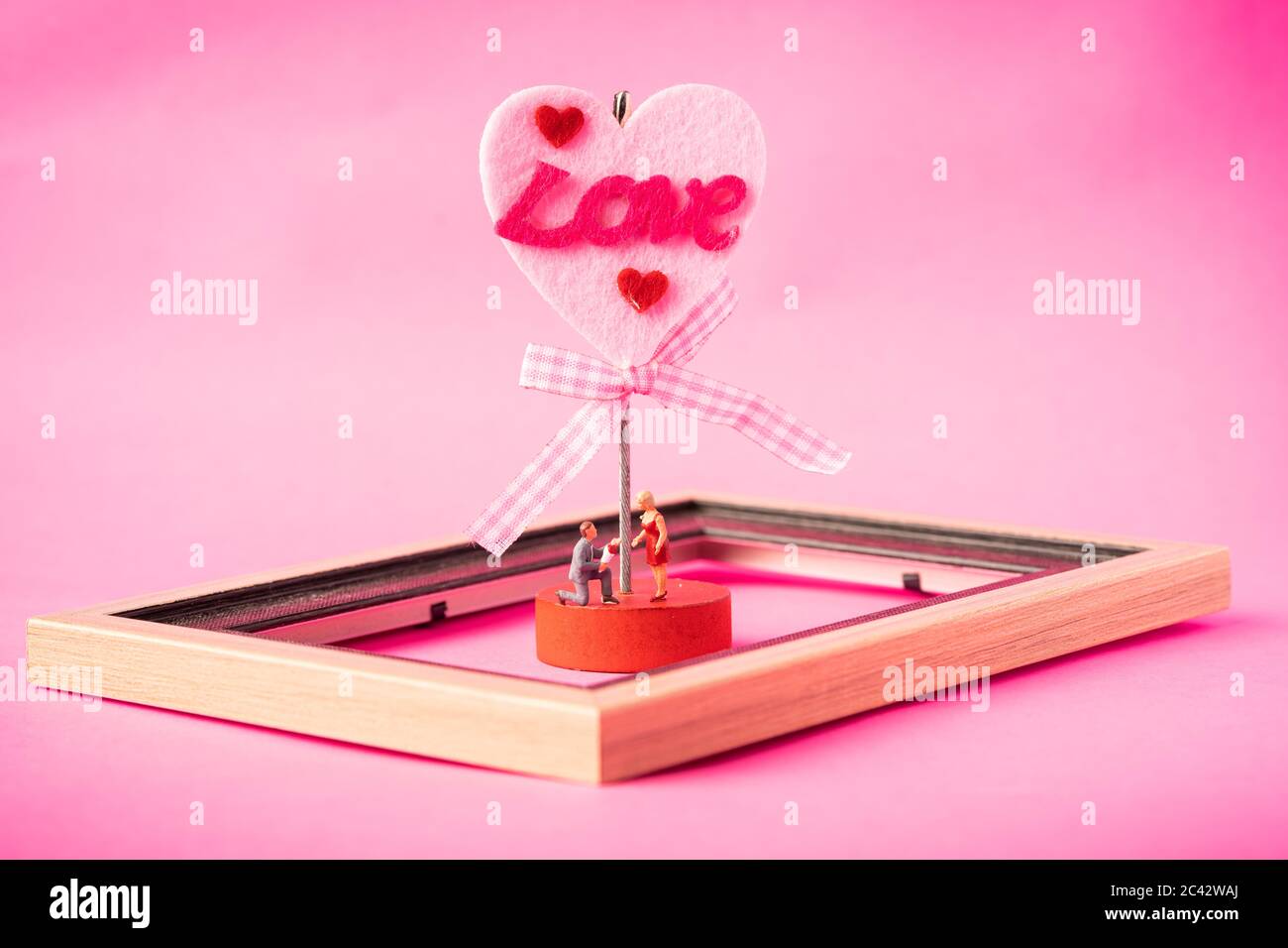 Love concept. Miniature couple against pink background Stock Photo - Alamy