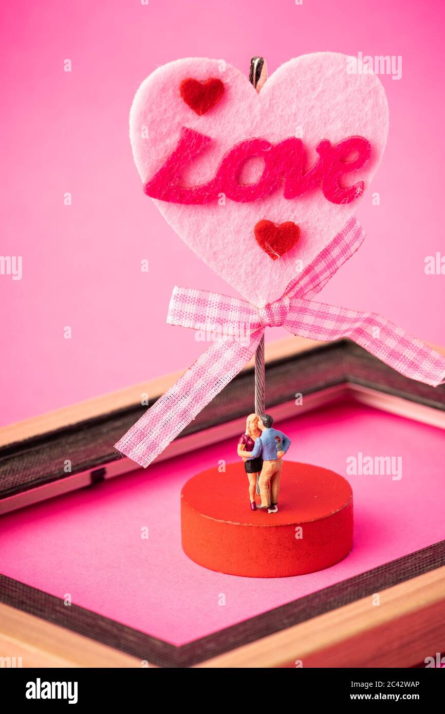 Love concept. Miniature couple against pink background Stock Photo - Alamy
