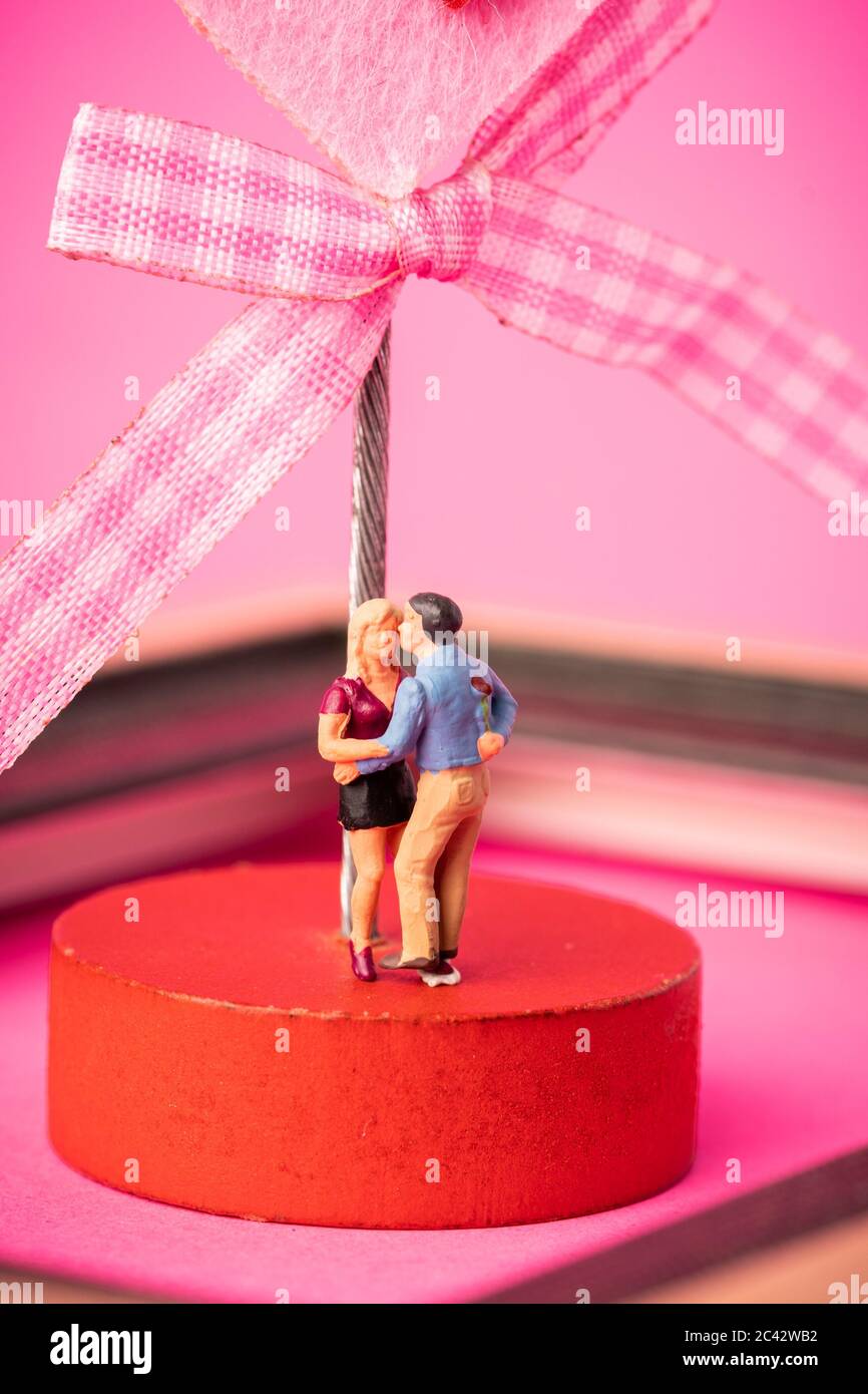 Love concept. Miniature couple against pink background Stock Photo - Alamy
