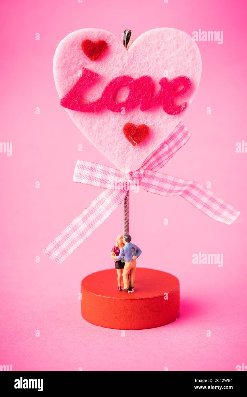 Love concept. Miniature couple against pink background Stock Photo - Alamy