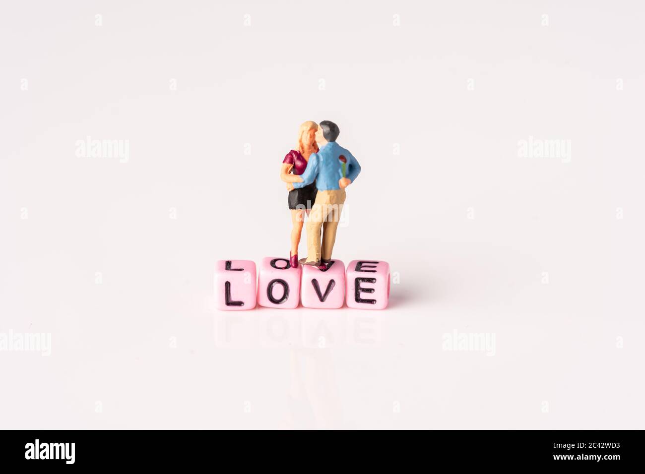 Love concept. Miniature couple against pink background Stock Photo - Alamy