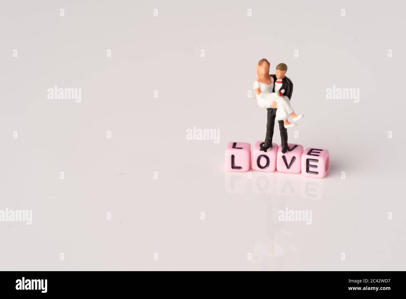Love concept. Miniature couple against pink background Stock Photo - Alamy